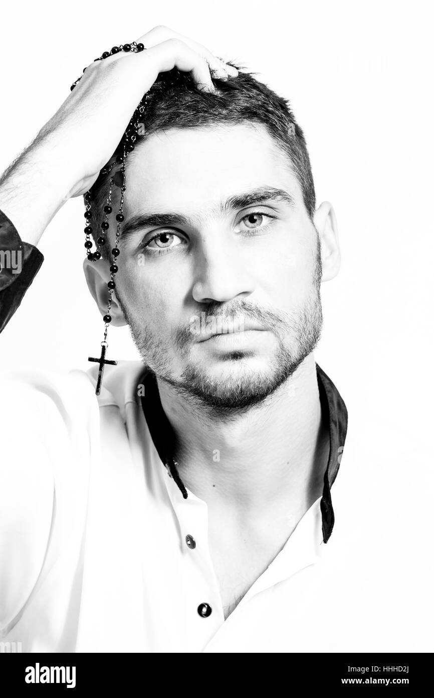 Man with rosary with a cross holding his head. Piercing eyes. Close-up ...