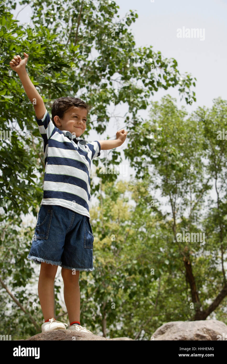 boy standing on rocks with arms up Stock Photo - Alamy