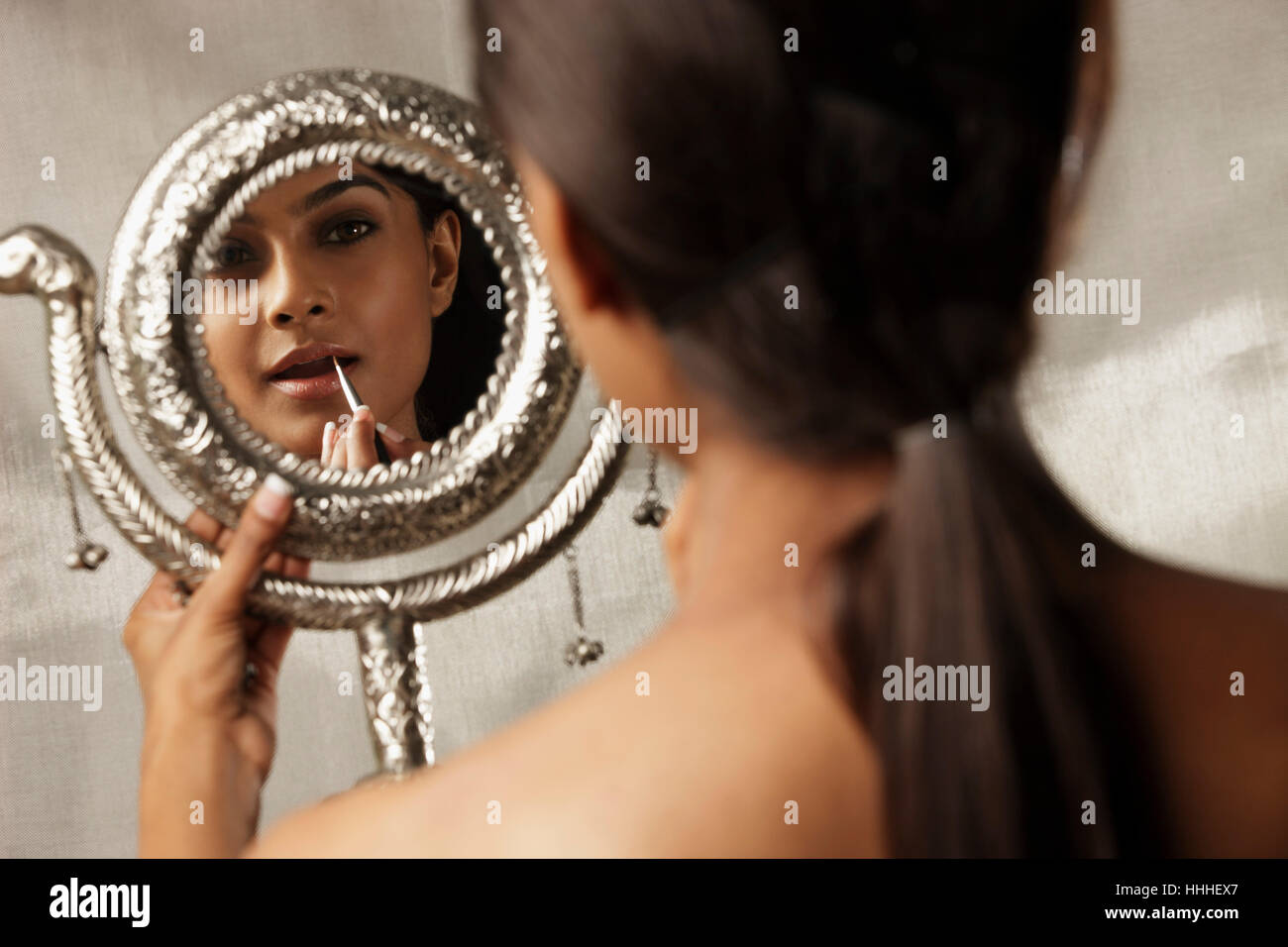 back view of woman holding up mirror with reflection Stock Photo - Alamy