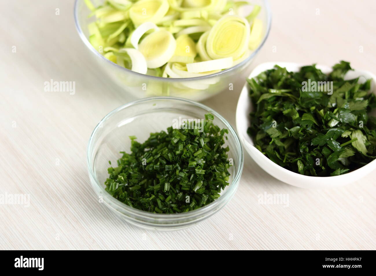 Minced chives, parsley and sliced leek in bowl. Making Potato and Leek ...