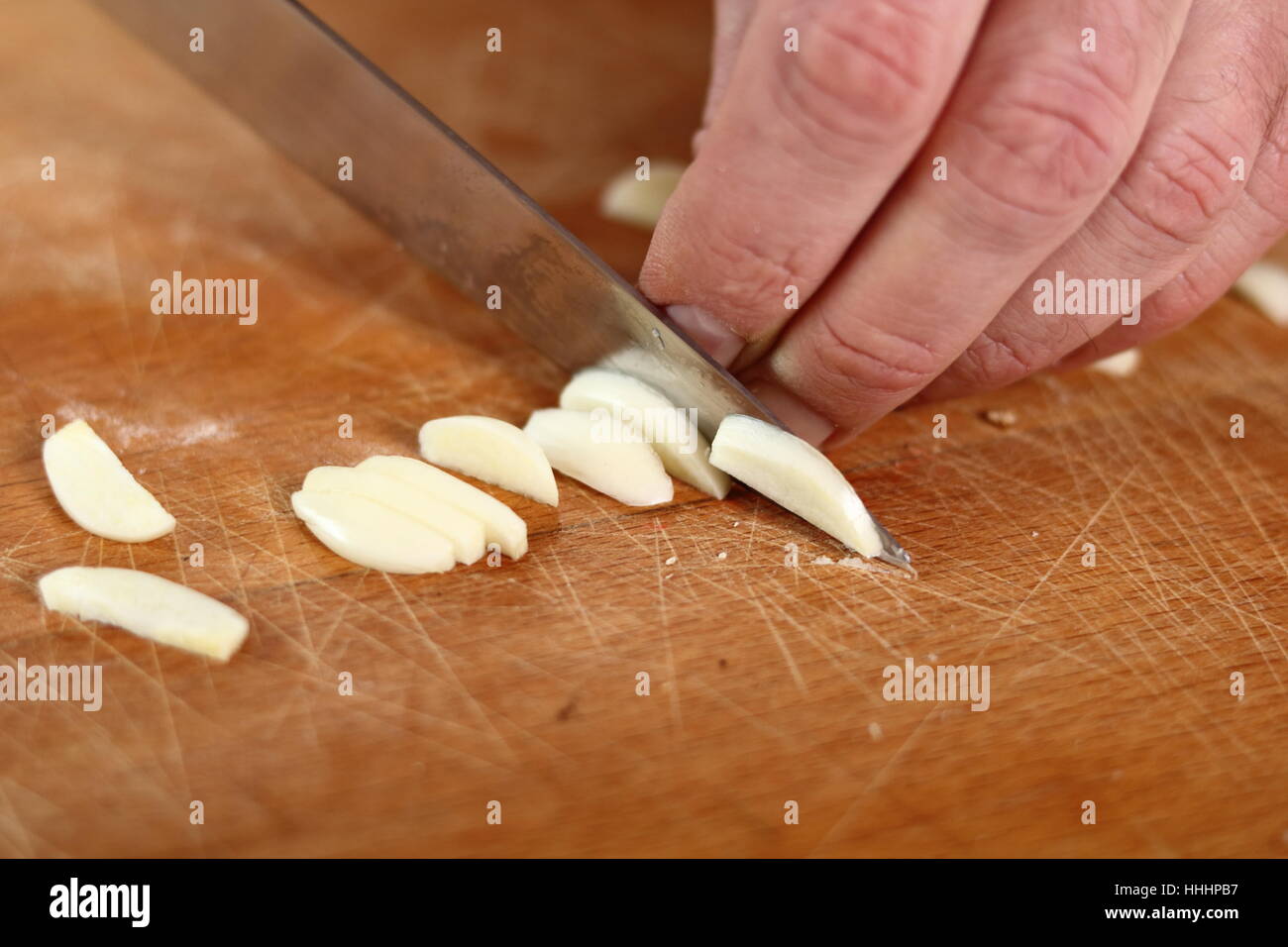 Slicing garlic. Making Potato and Leek Filo Pie. Series Stock Photo - Alamy