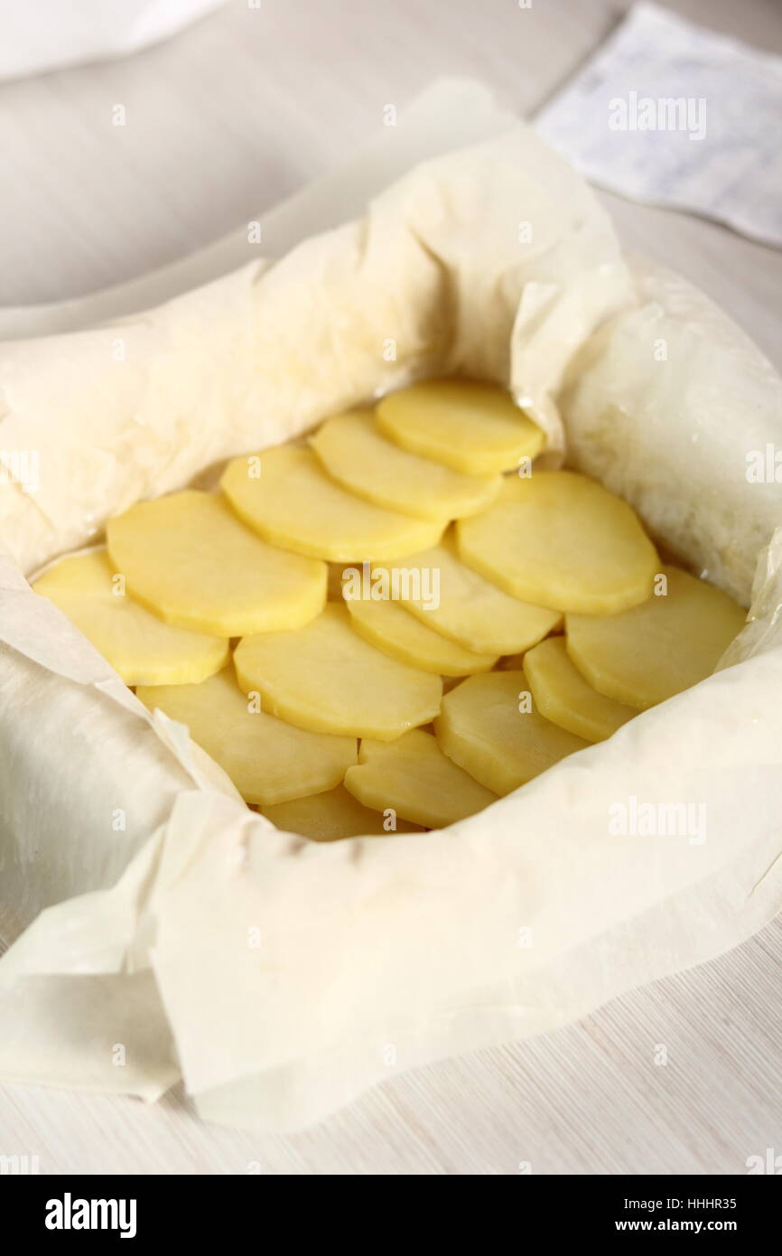 Layer potato slices. Making Potato and Leek Filo Pie. Series Stock ...