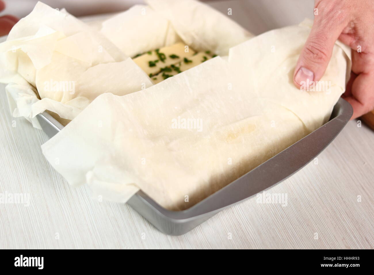 Fold pastry over filling. Making Potato and Leek Filo Pie. Series Stock ...