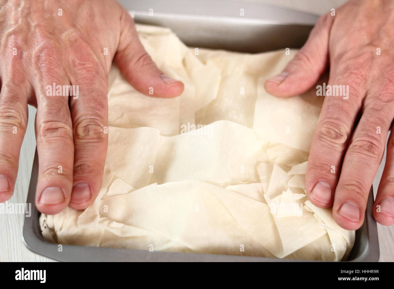 Fold pastry over filling. Making Potato and Leek Filo Pie. Series Stock ...
