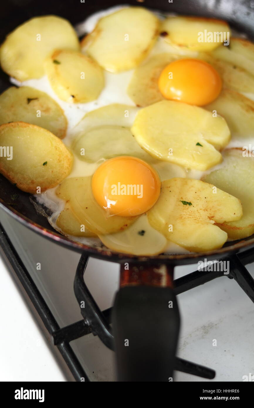 Making sunny side up eggs with fried potato Stock Photo - Alamy