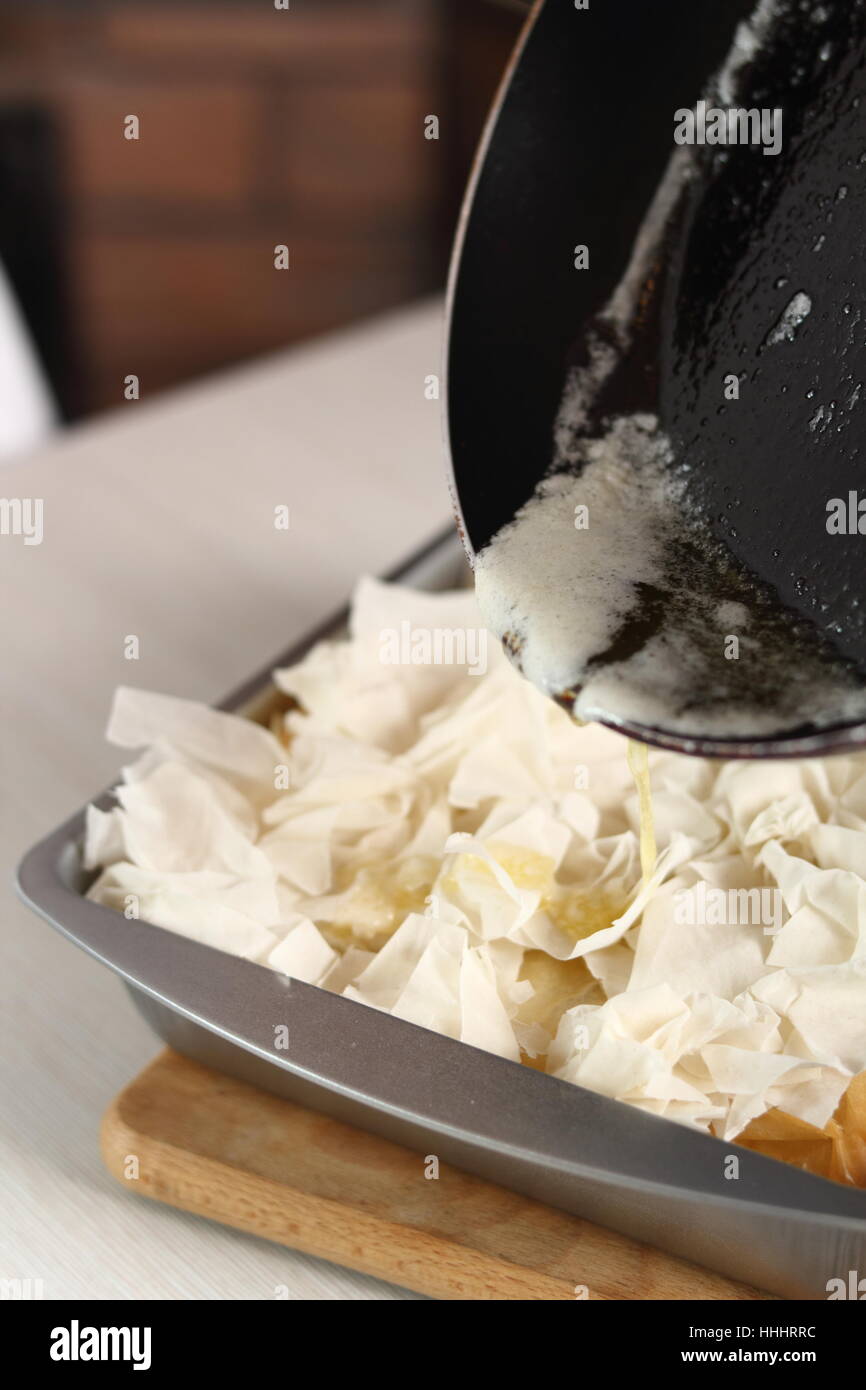 Pouring melted butter on top of pie. Making Potato and Leek Filo Pie ...