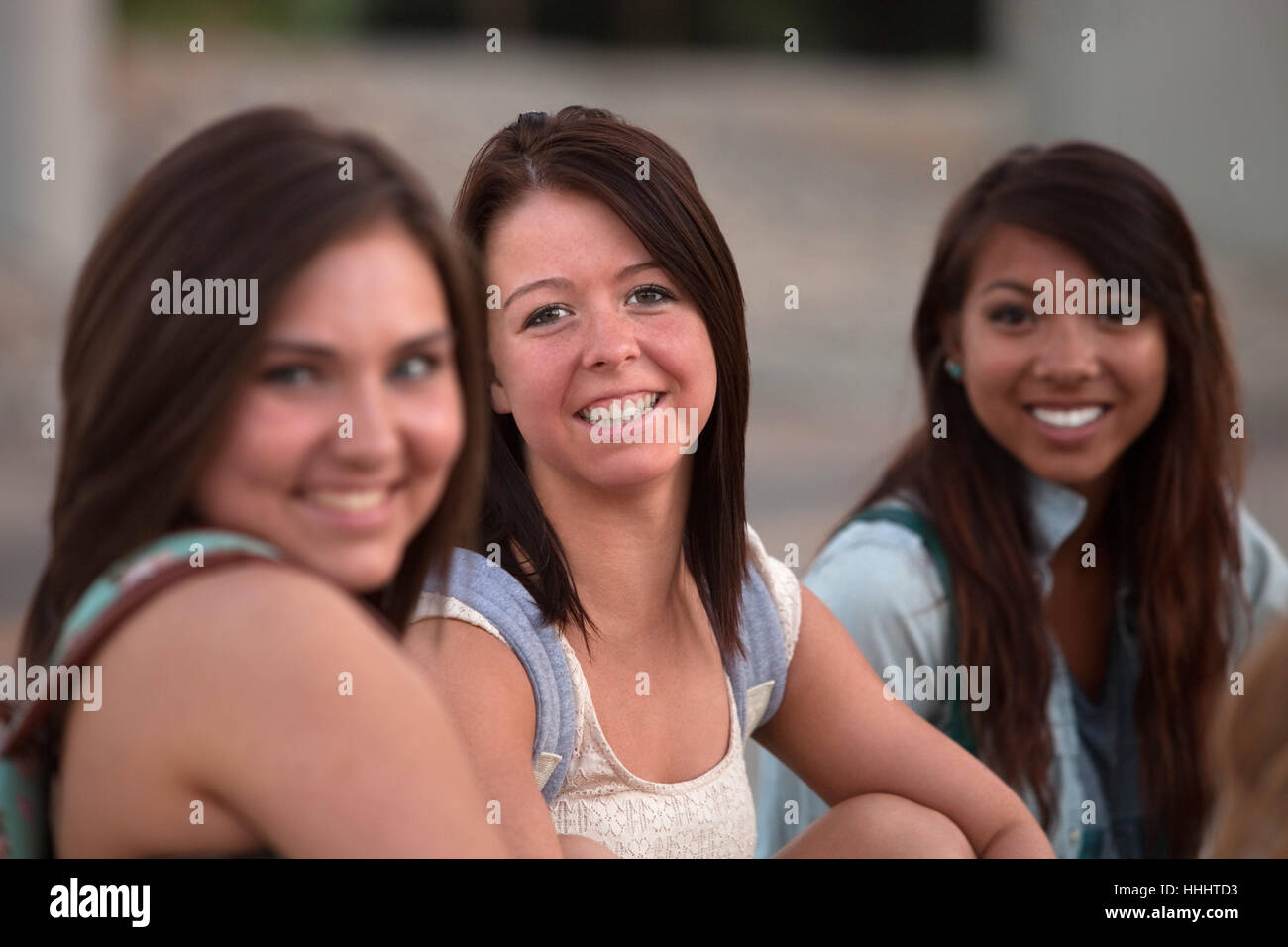 Three pretty teenage students smiling and sitting together Stock Photo ...