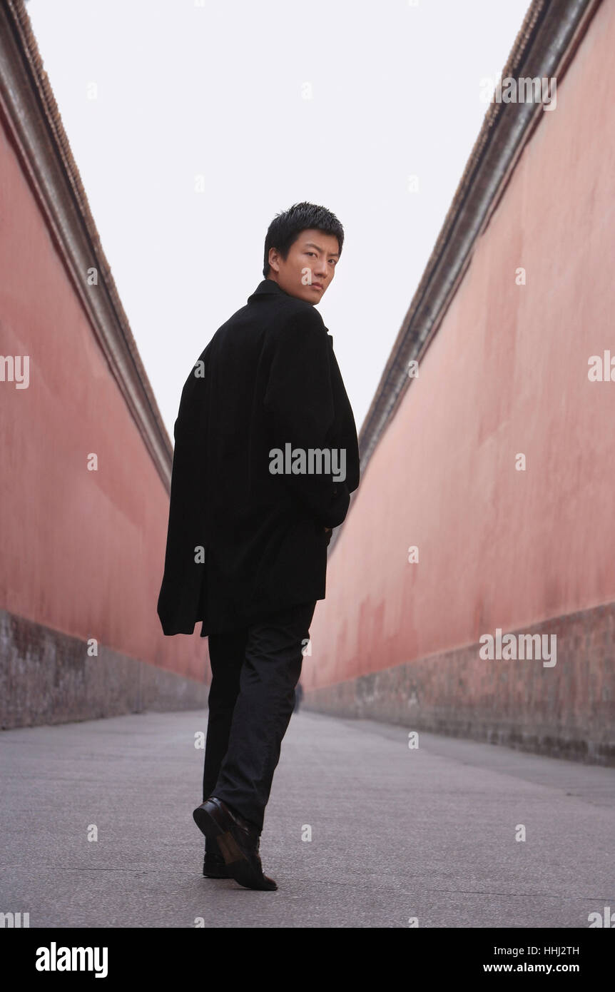 A man looks back at the camera as he walks away Stock Photo - Alamy