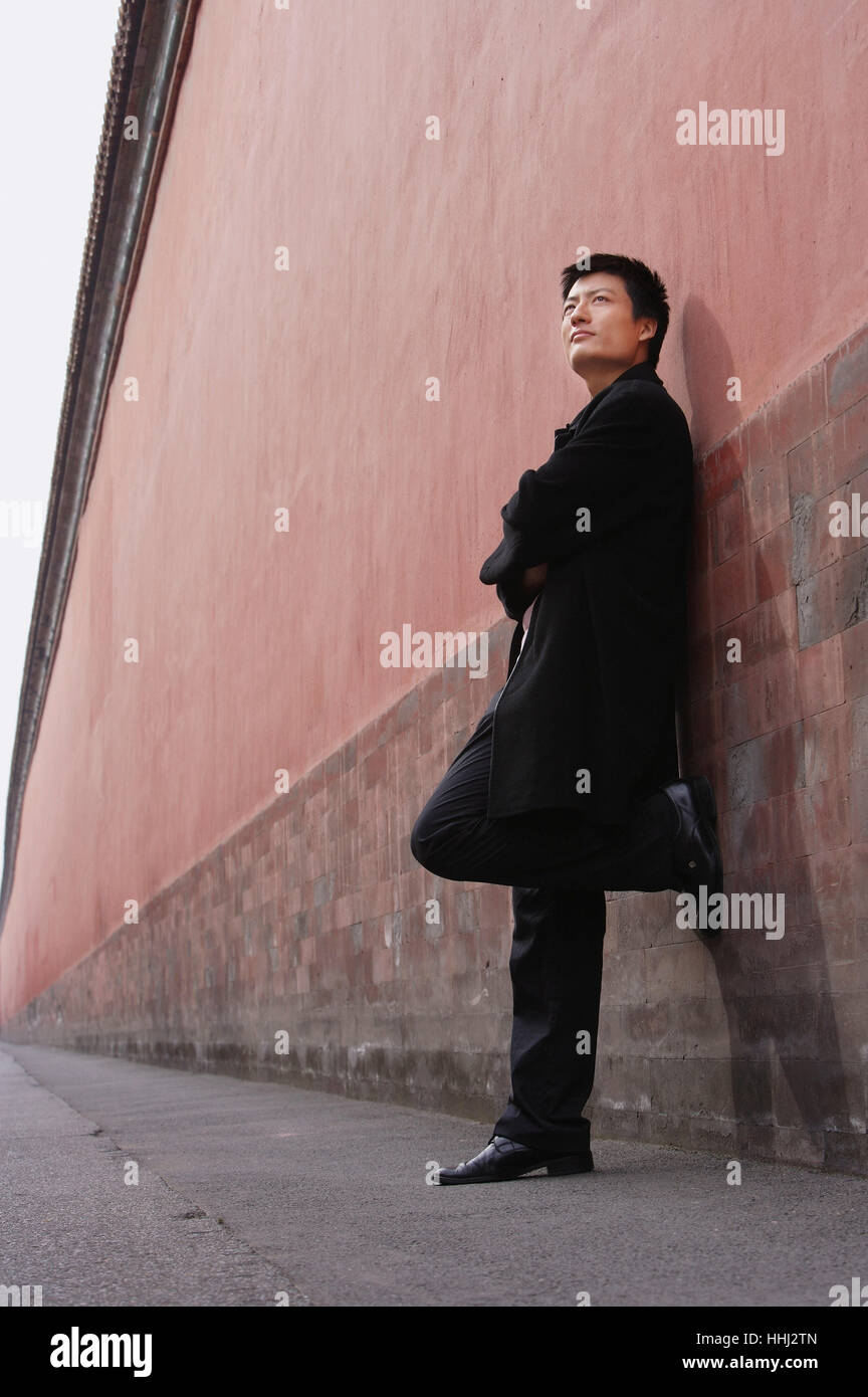 A man leans against a wall Stock Photo - Alamy