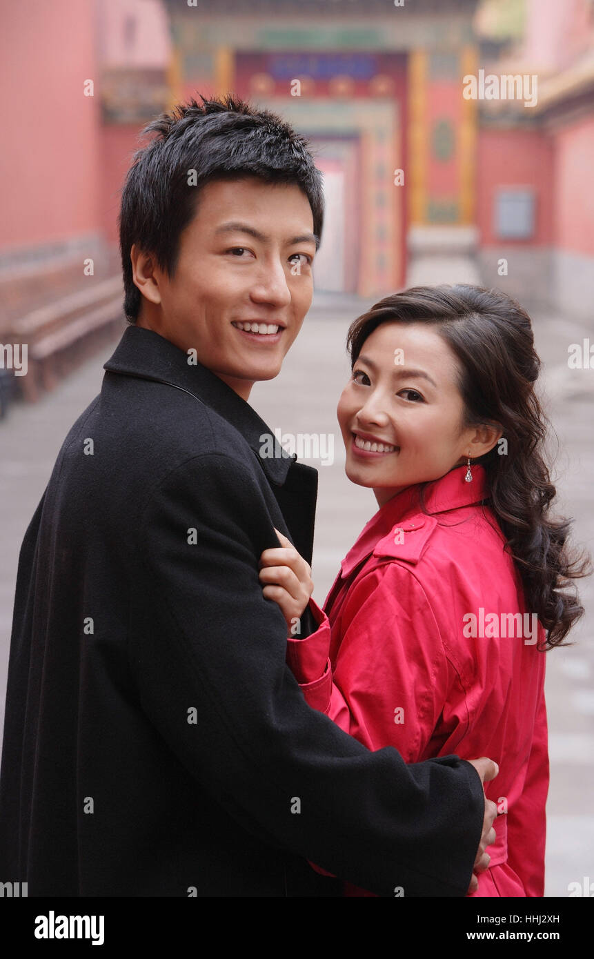 A couple hug and smile as they look at the camera Stock Photo - Alamy