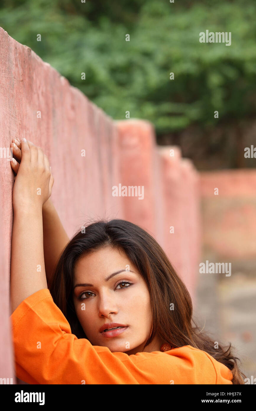 woman leaning against a wall Stock Photo - Alamy