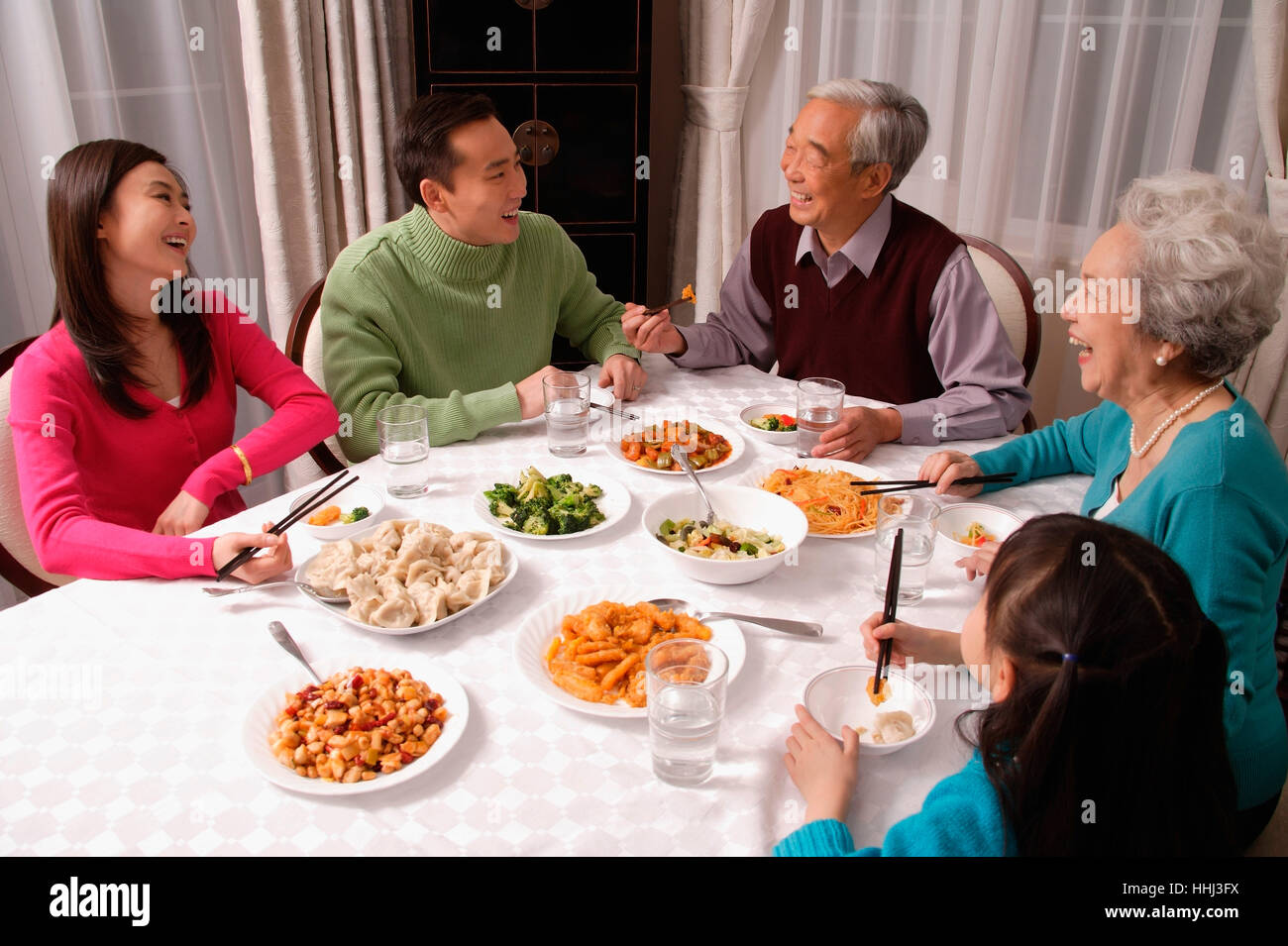 Family at dinner table having traditional food Stock Photo - Alamy