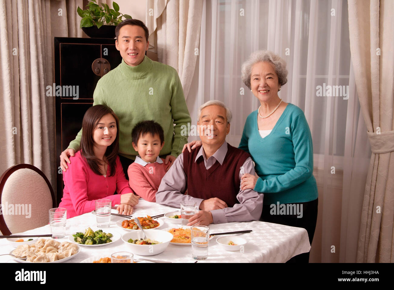 Family at dinner table with traditional food Stock Photo - Alamy