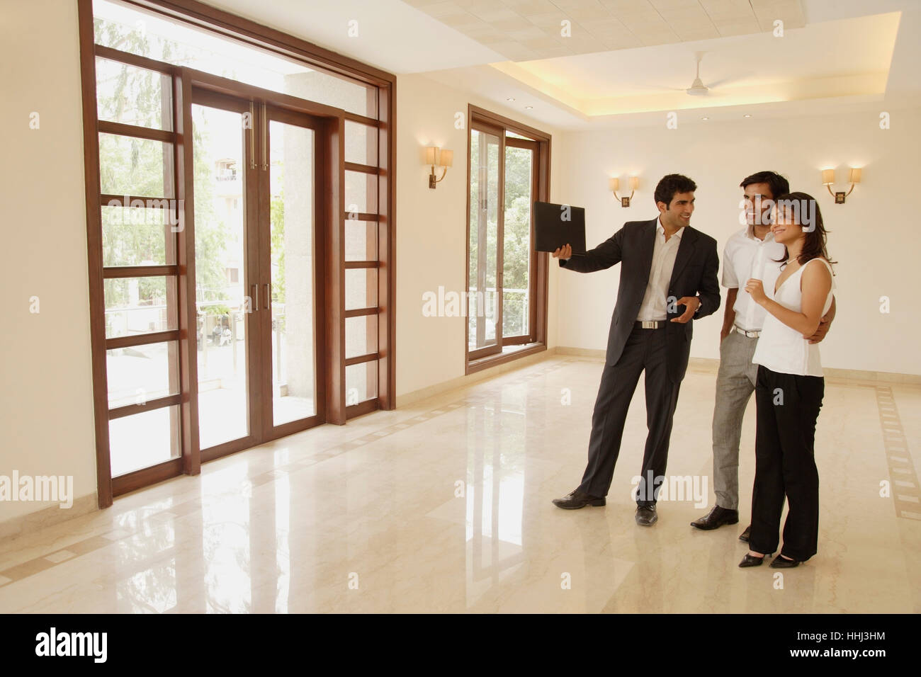 agent with young couple Stock Photo - Alamy