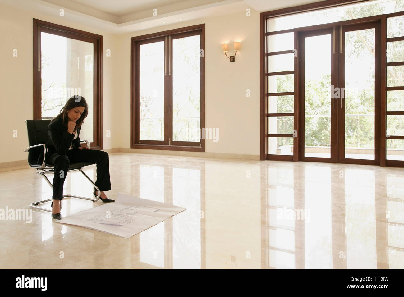 Woman looking at blueprints Stock Photo - Alamy