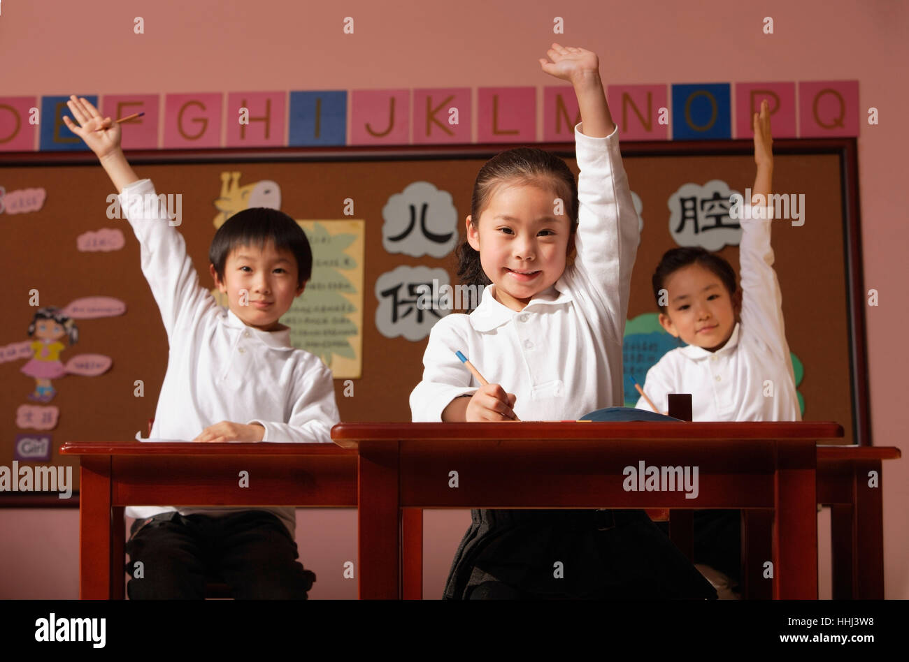 Students in class raising hands Stock Photo - Alamy