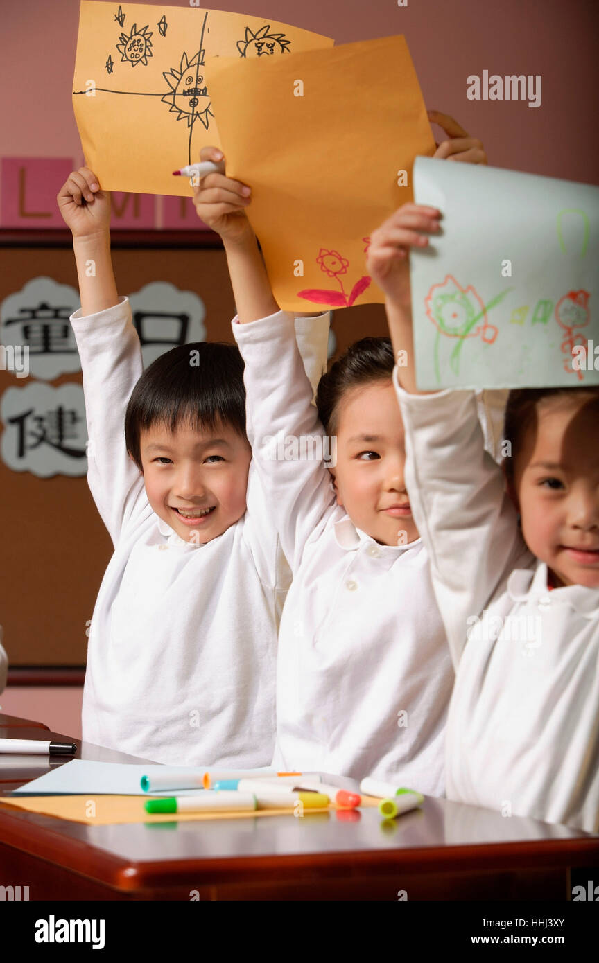 Young students showing off drawings Stock Photo - Alamy