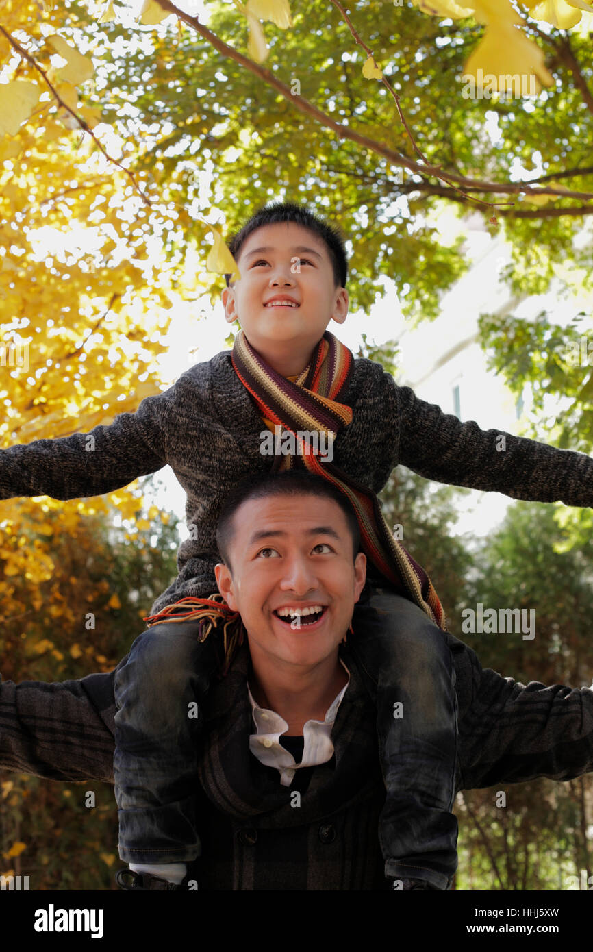 Young boy on dad's shoulders looking up Stock Photo - Alamy
