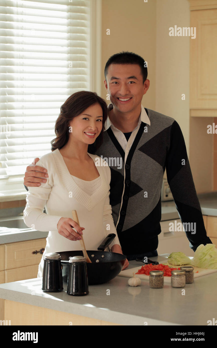 Young couple cooking together in the kitchen Stock Photo - Alamy
