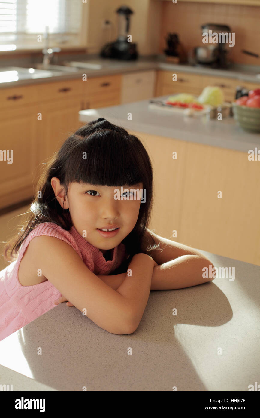 Young girl sitting at the kitchen counter Stock Photo - Alamy
