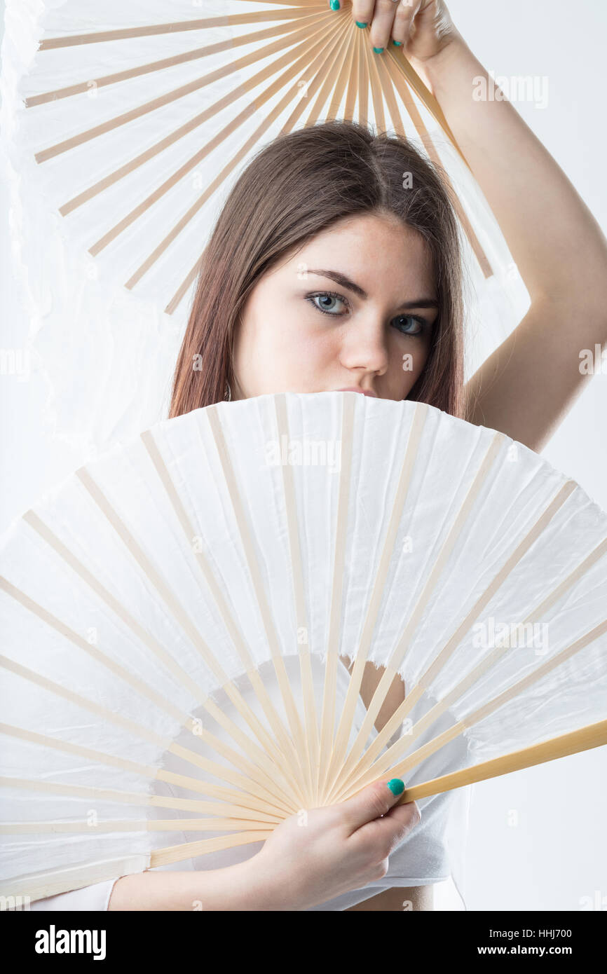 model or dancer posing and hiding behind a couple of fan Stock Photo ...