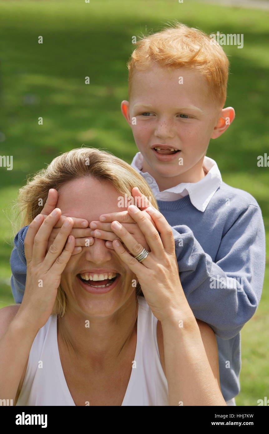 boy with hands over woman's eyes Stock Photo - Alamy