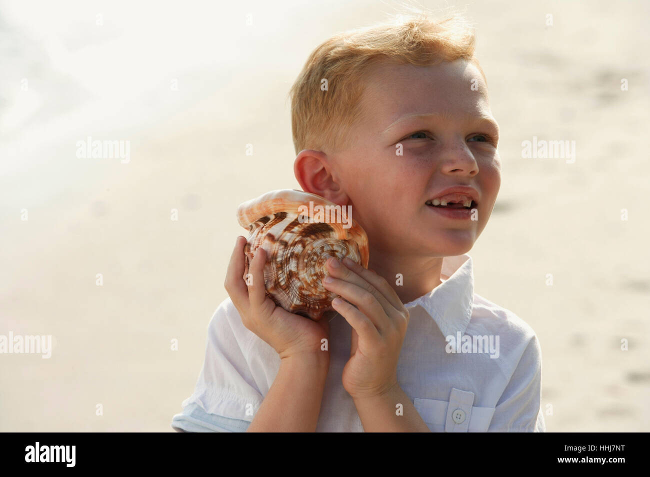 boy listening to seashell Stock Photo - Alamy