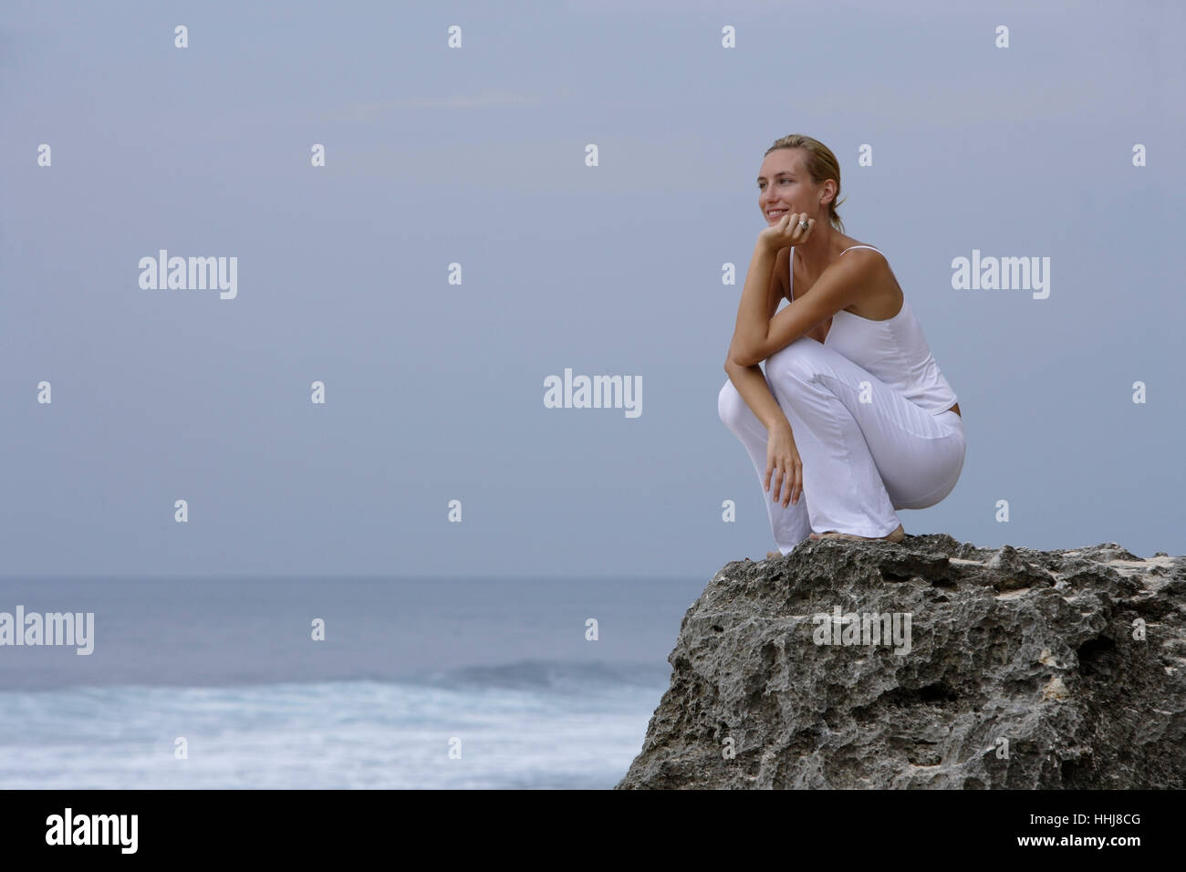 woman on rocks, watching ocean Stock Photo - Alamy