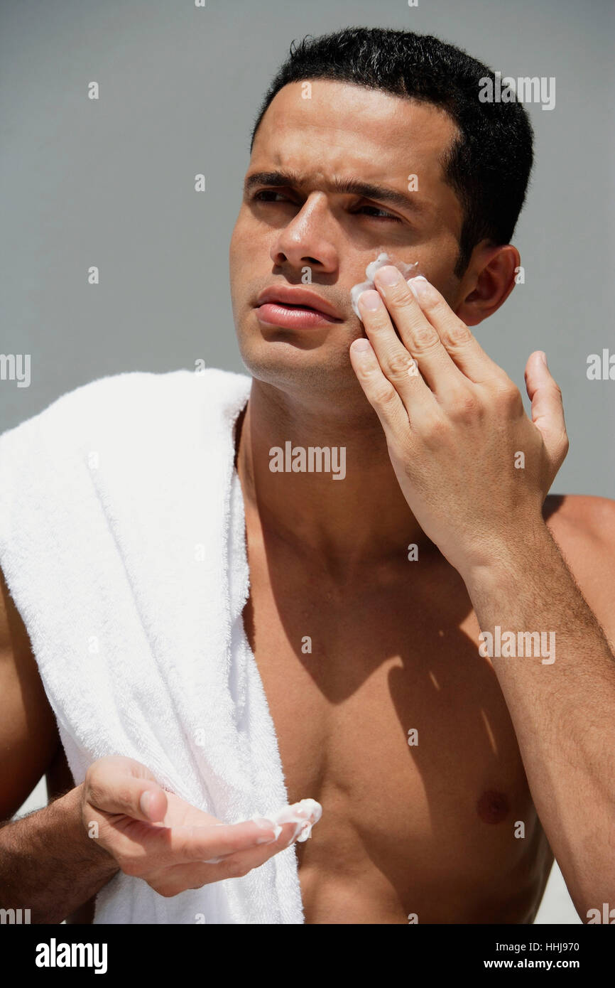 Man applying moisturizer to face Stock Photo - Alamy