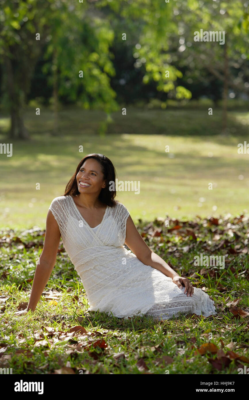 Woman sitting on grass Stock Photo - Alamy