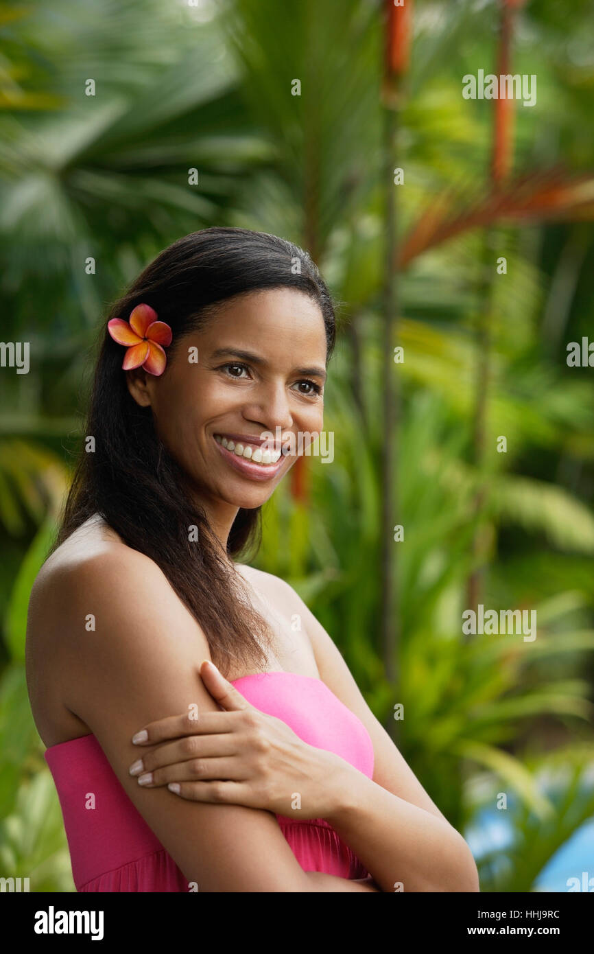 Woman standing with flower behind ear Stock Photo - Alamy