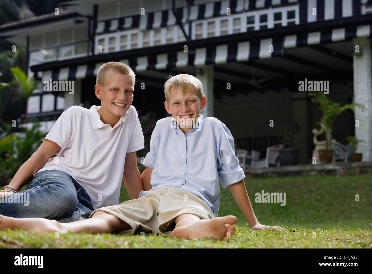 two boys sitting on grass Stock Photo - Alamy