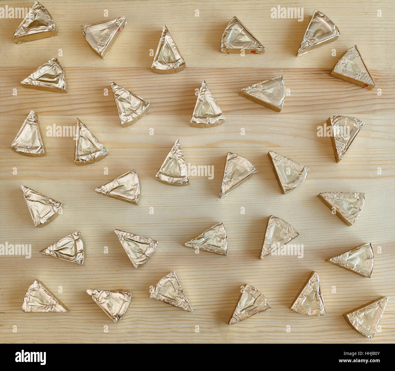 triangles of processed cheese on a wooden table in a variety of forms ...