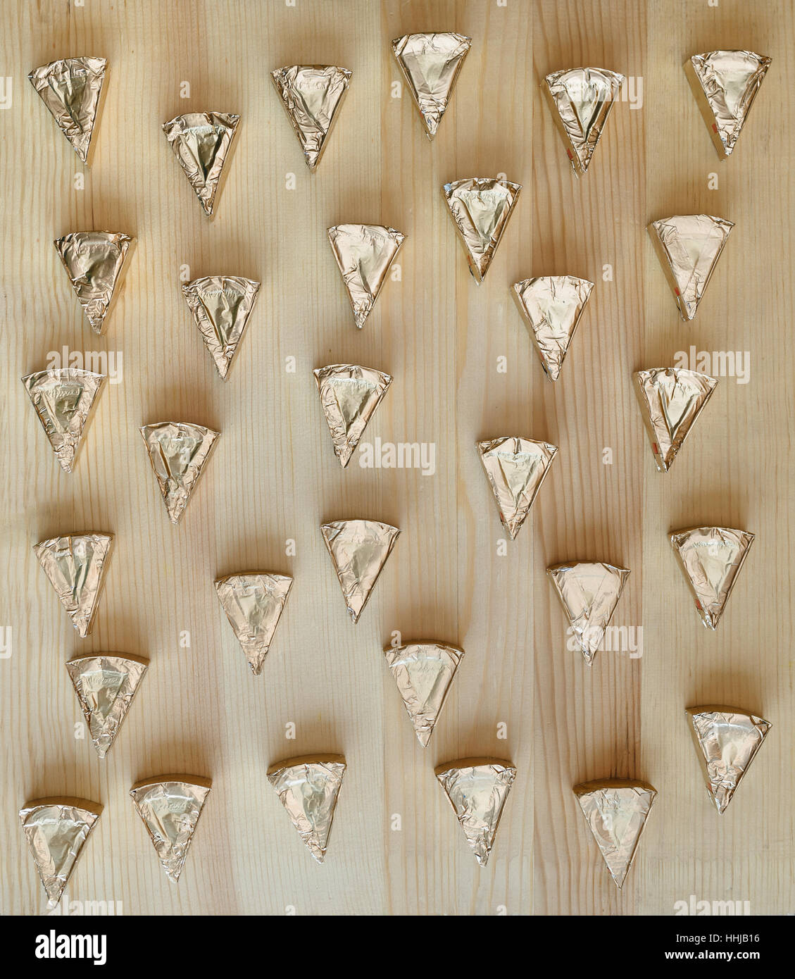 triangles of processed cheese on a wooden table in a variety of forms ...