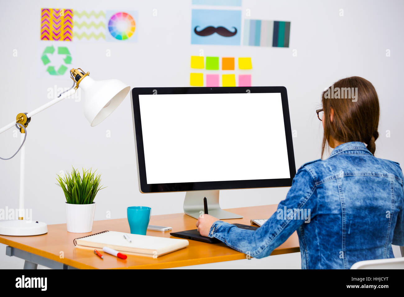 Woman working at desk In a creative office, using a computer Stock ...