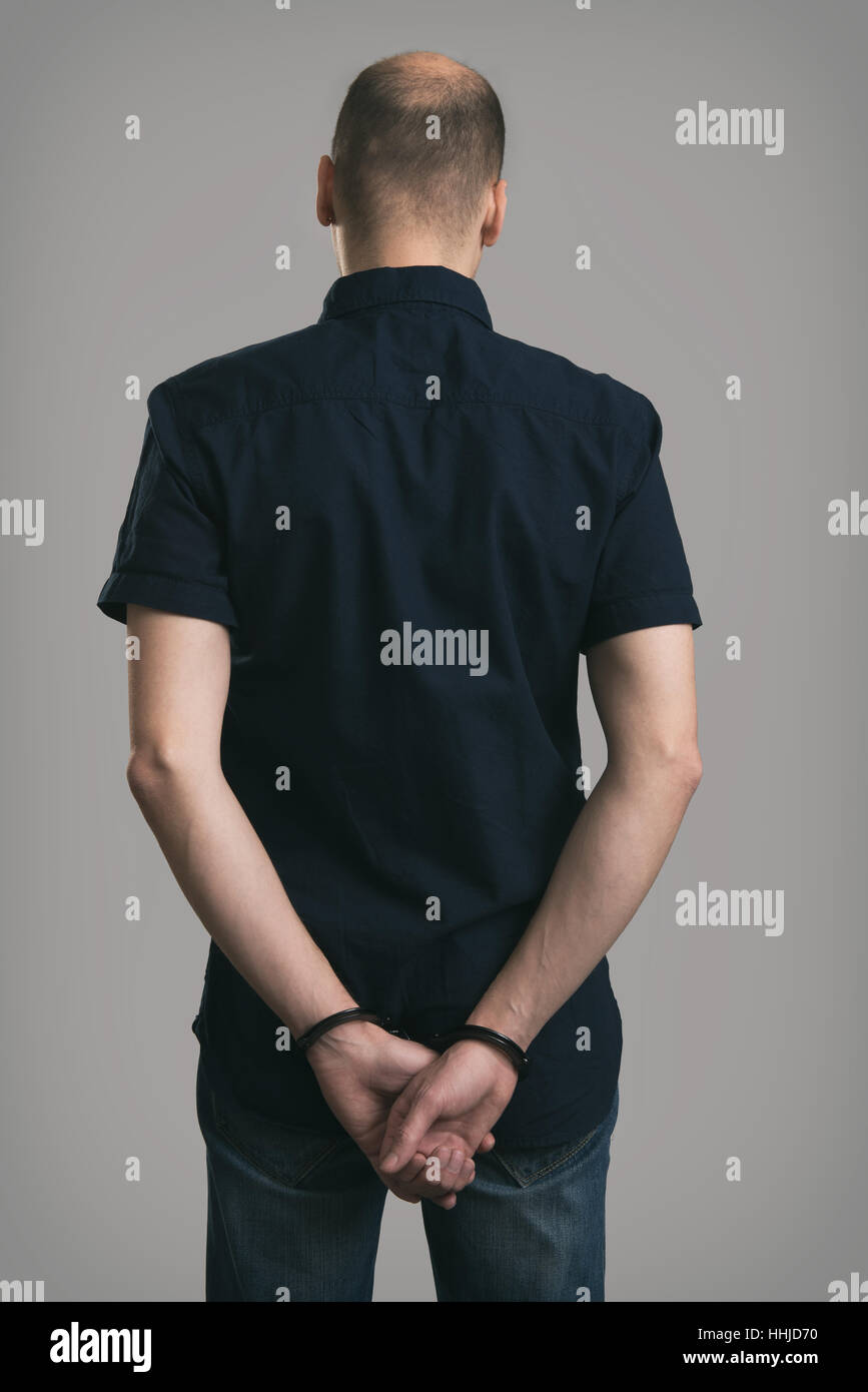 arrested caucasian man with handcuffs. Back view Stock Photo - Alamy