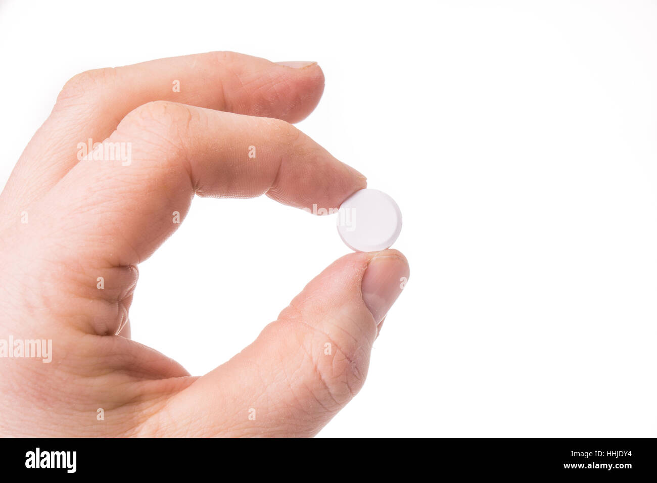 hand holding small round pill. Hand and medicines are isolated on white ...