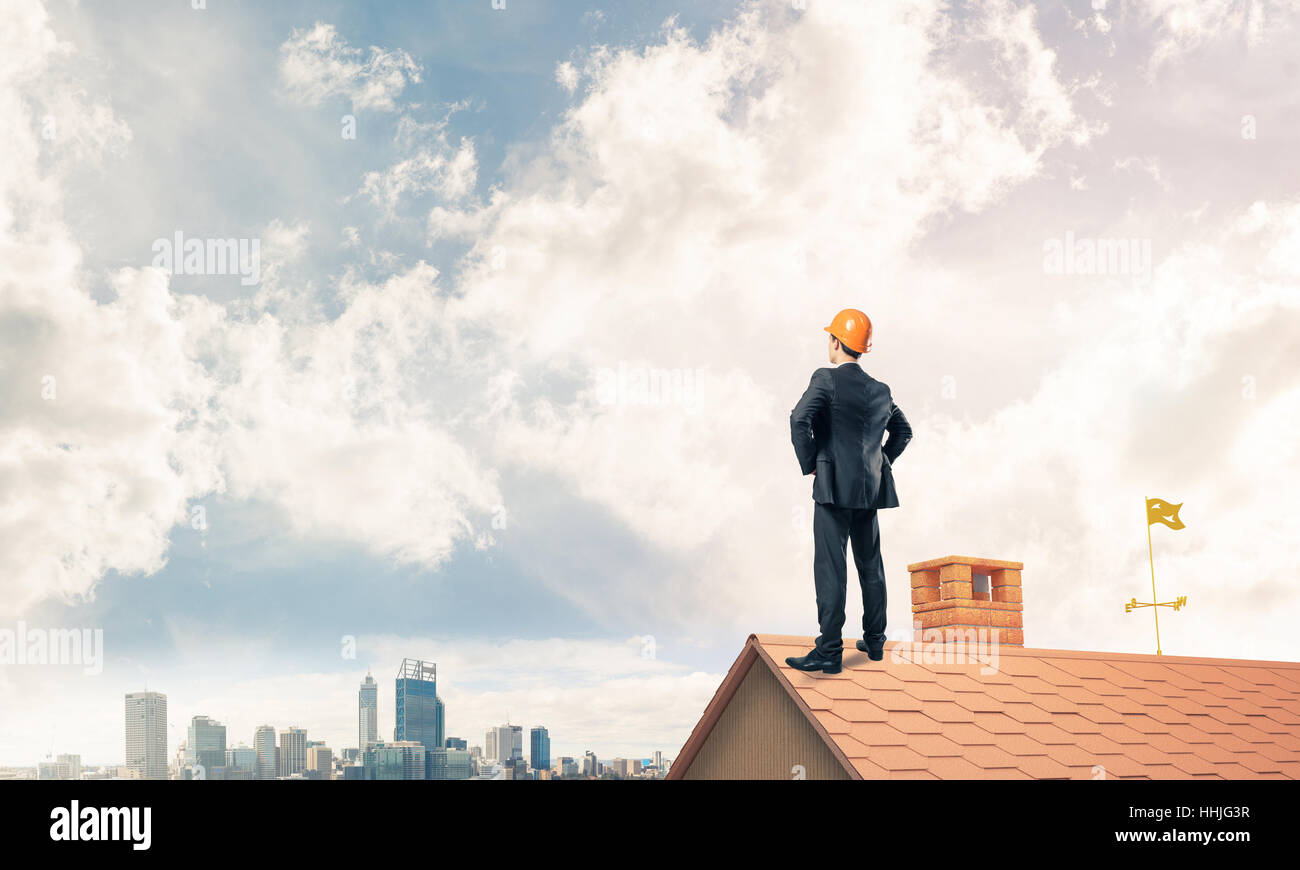 Engineer man standing on roof and looking away. Mixed media Stock Photo ...