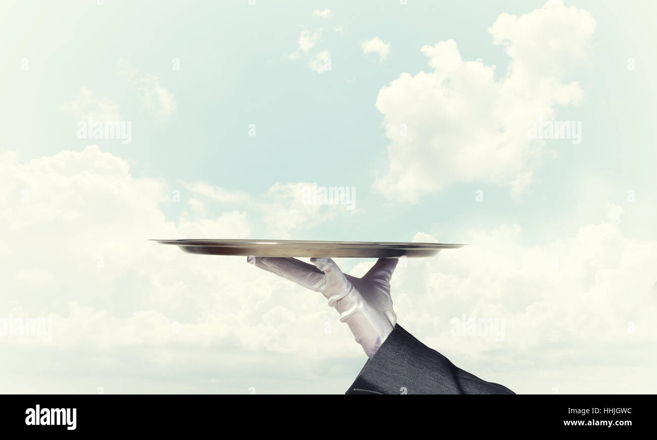 Waiter holding empty silver platter ready for product or item placement ...