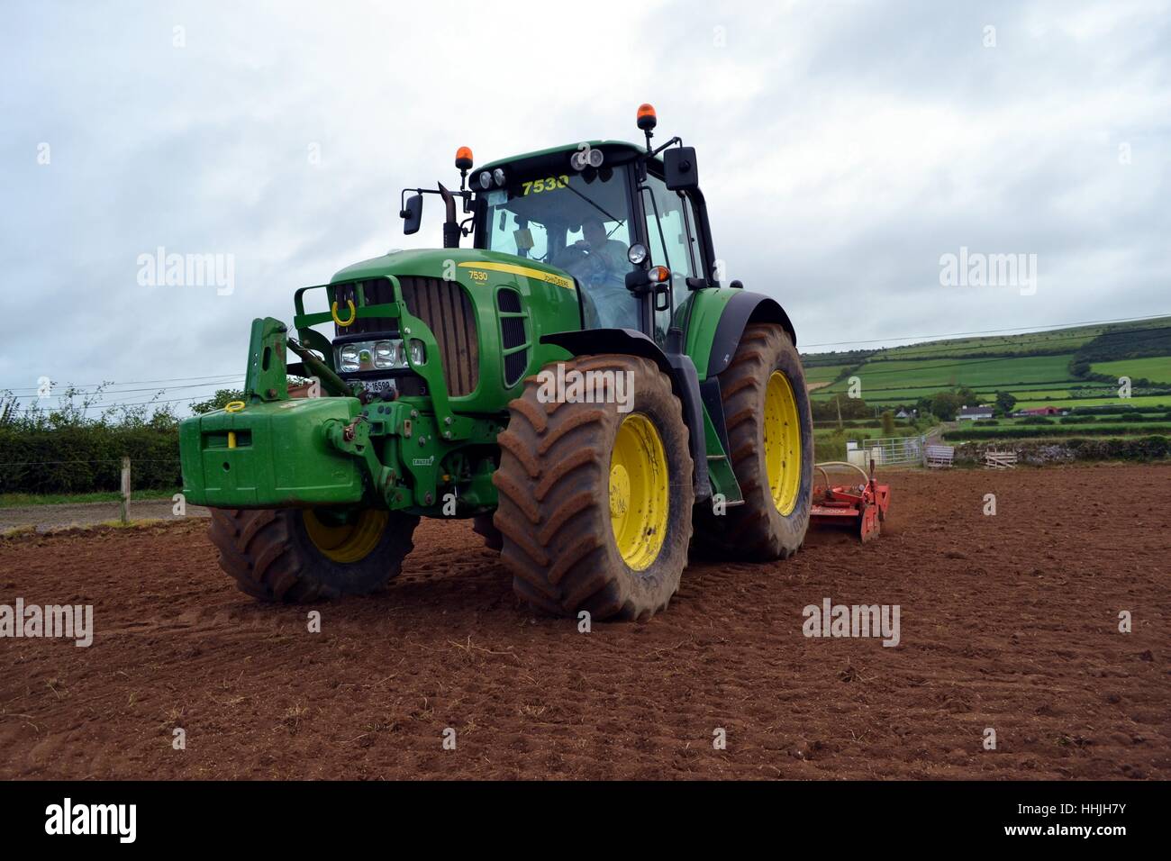 tractor and seeder sowing grass Stock Photo - Alamy