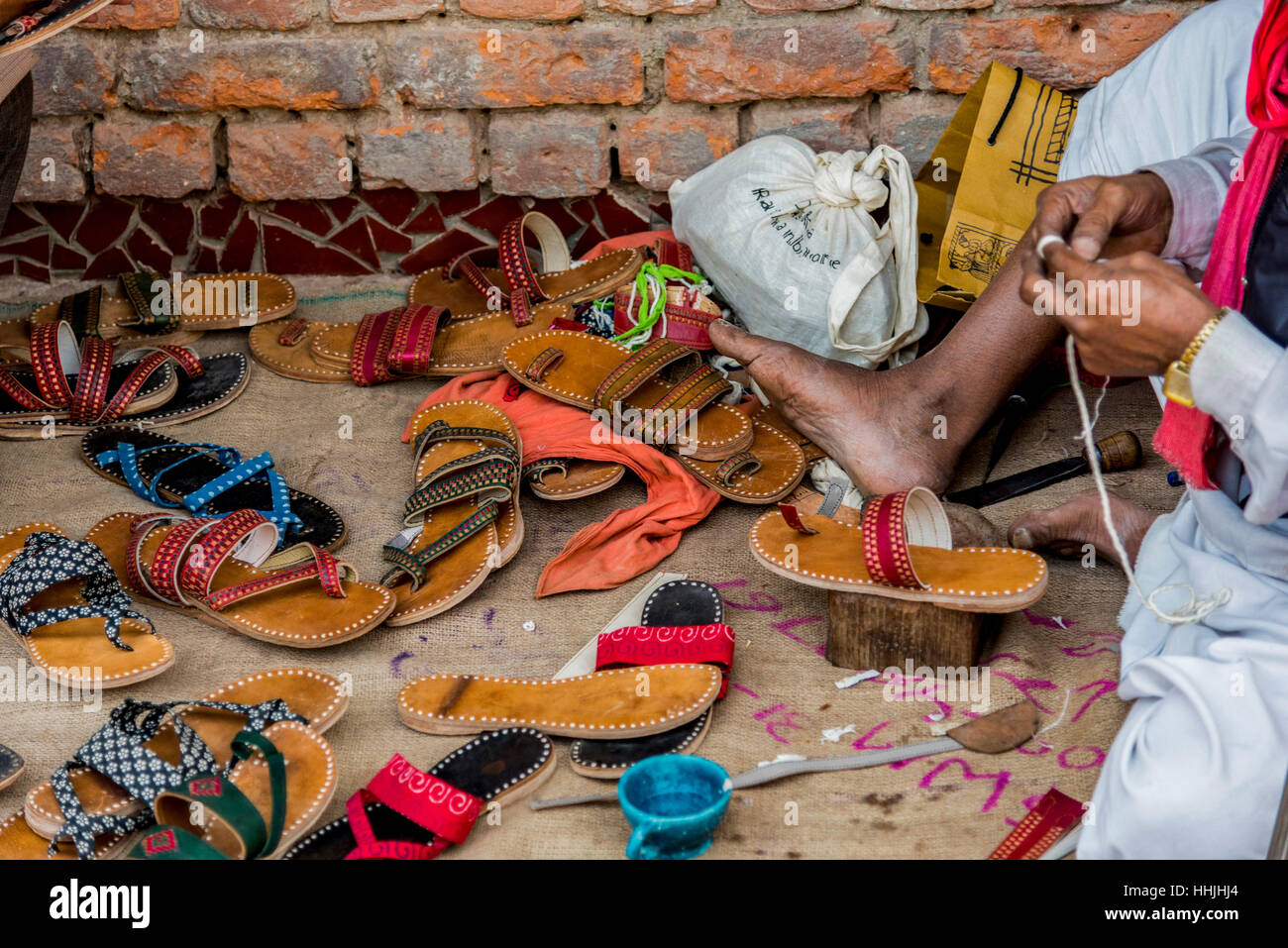 A local skilled cobbler making shoes and slippers at his shop for sale ...