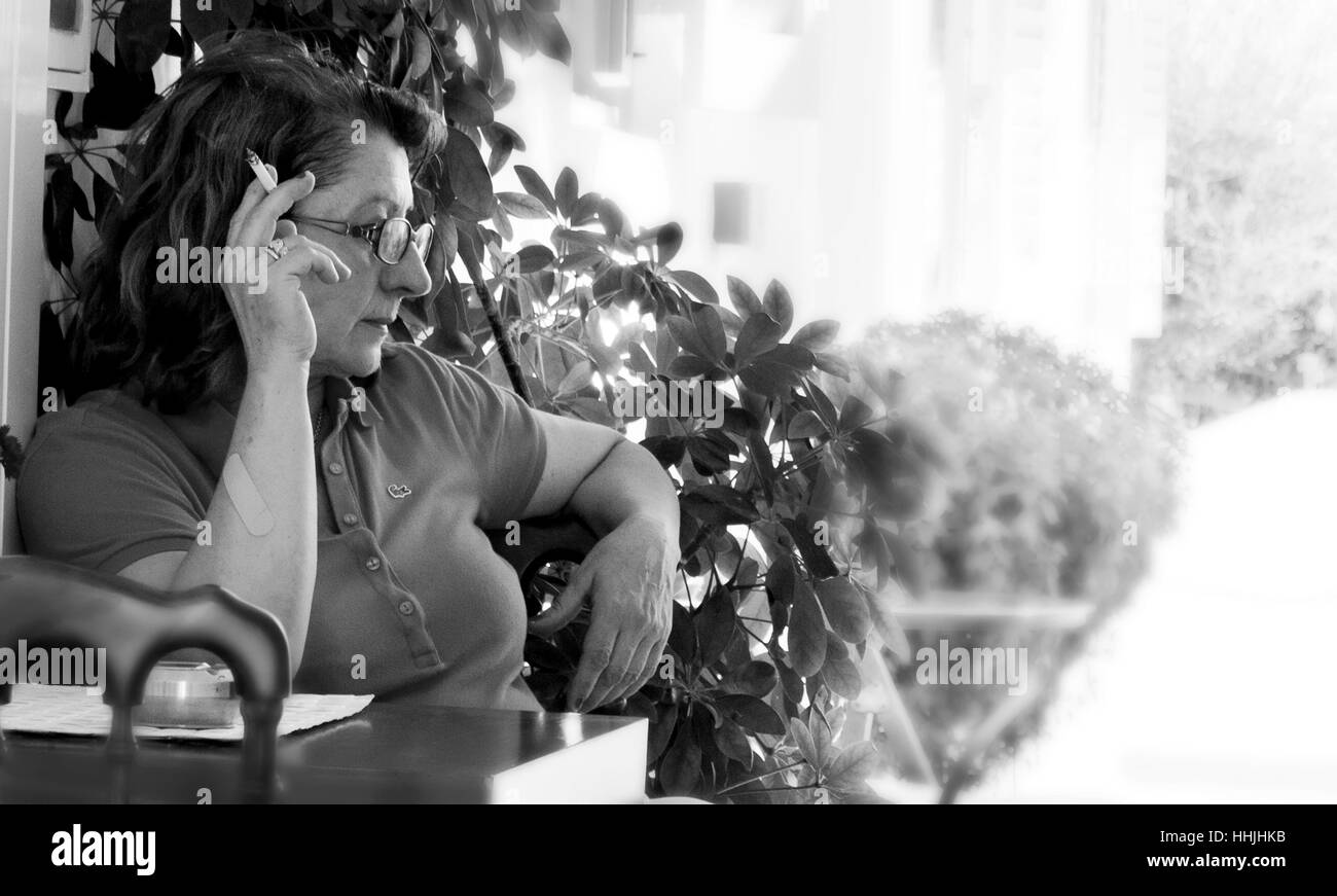 Woman smoking by window hi-res stock photography and images - Alamy