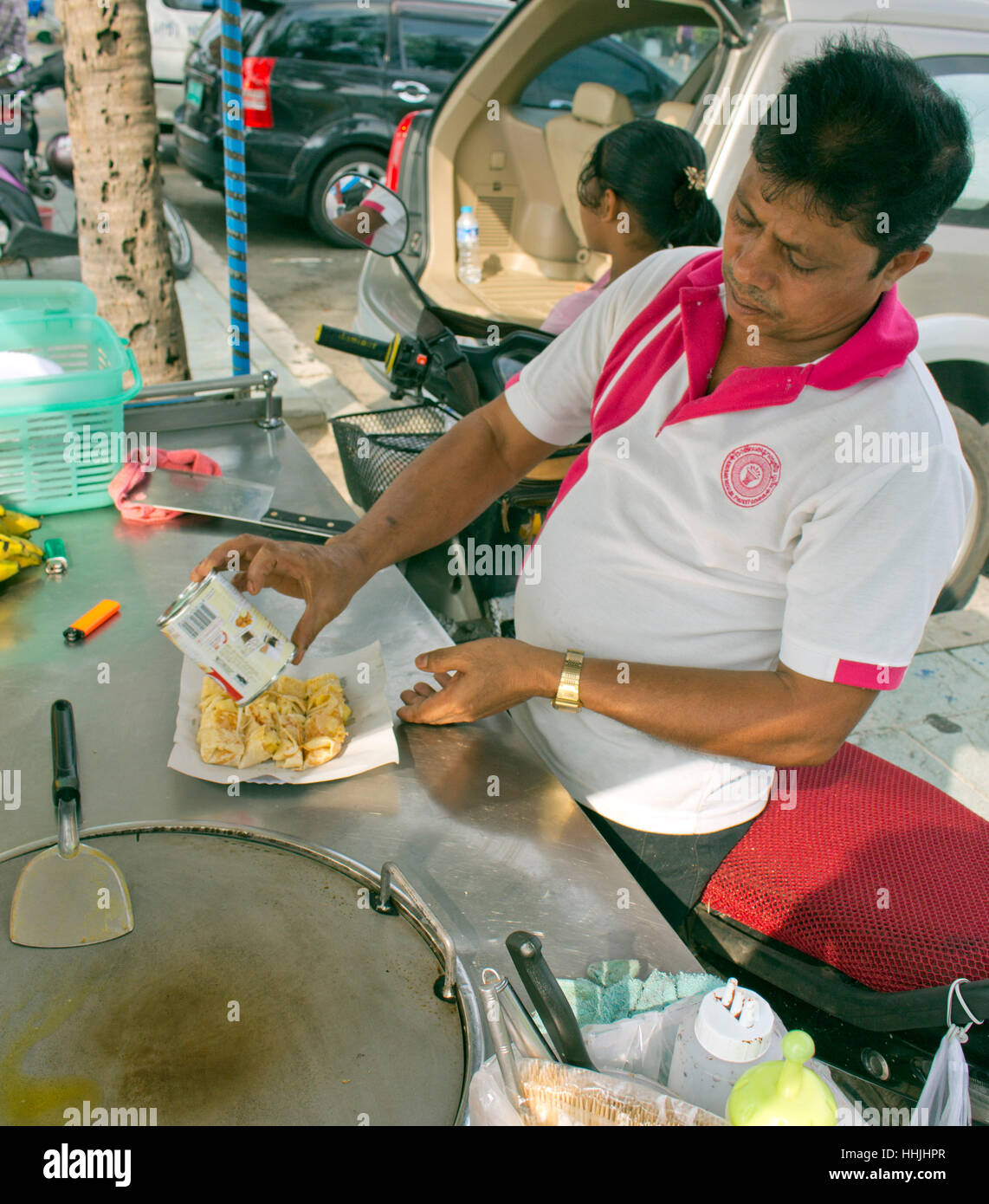 Man preparing a dessert style of fried Roti with banana. Phuket ...