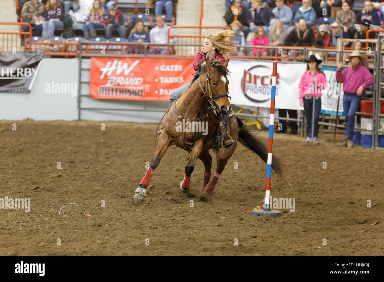 A young cowgirl competes in the high school pole racing event at the ...