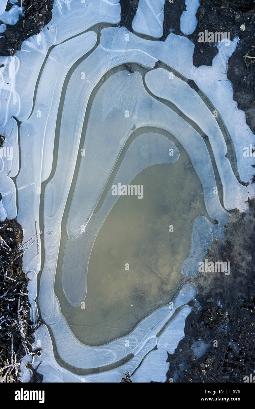 Ice pattern on frozen puddle of water Stock Photo - Alamy