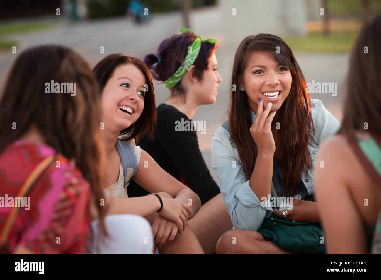 Interested female teenager in conversation with friends Stock Photo - Alamy