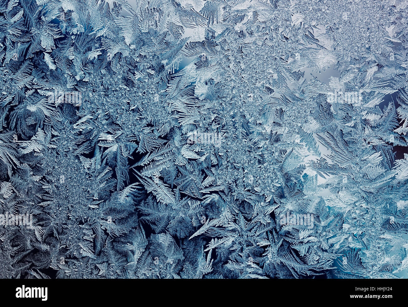 Intricate, delicate patterns of frost crystals on a sparkling glass ...