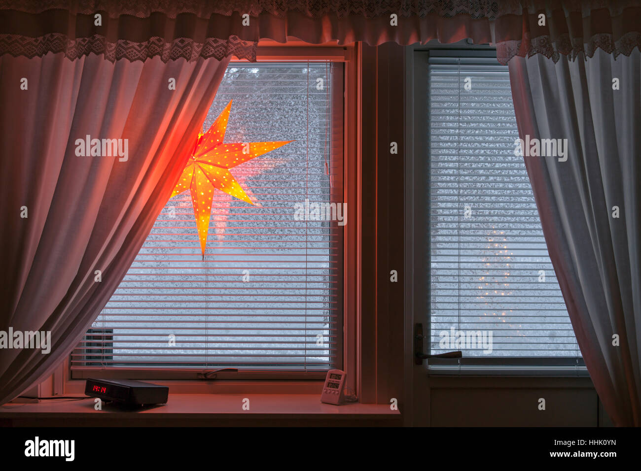 An Advent star, Christmas lights in a window. Snowy windows, curtains ...