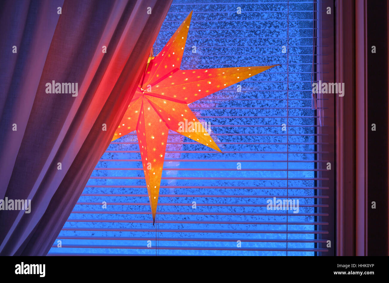 An Advent star, Christmas lights in a window. Snowy windows, curtains ...