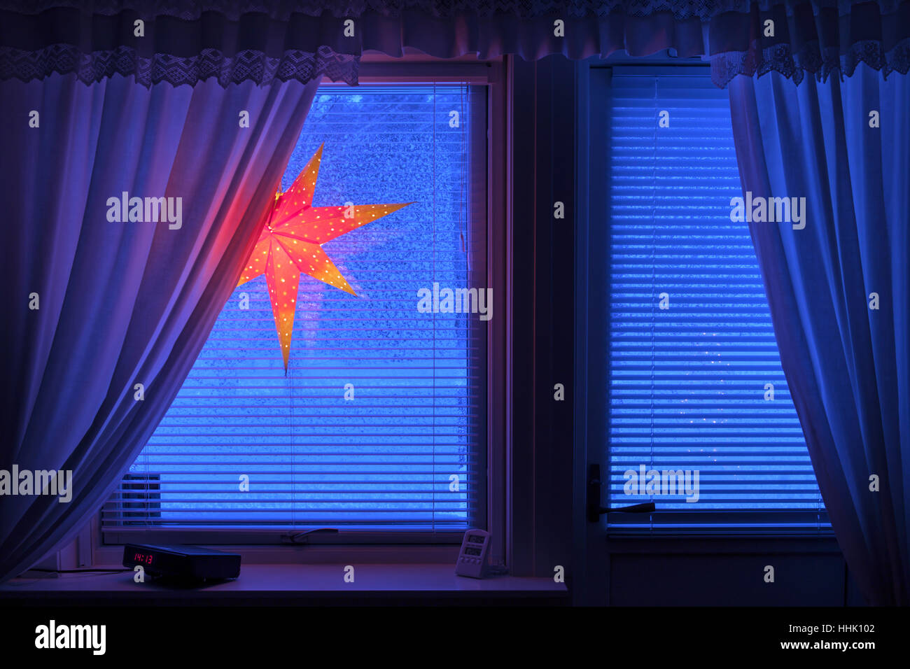 An Advent star, Christmas lights in a window. Snowy windows, curtains ...